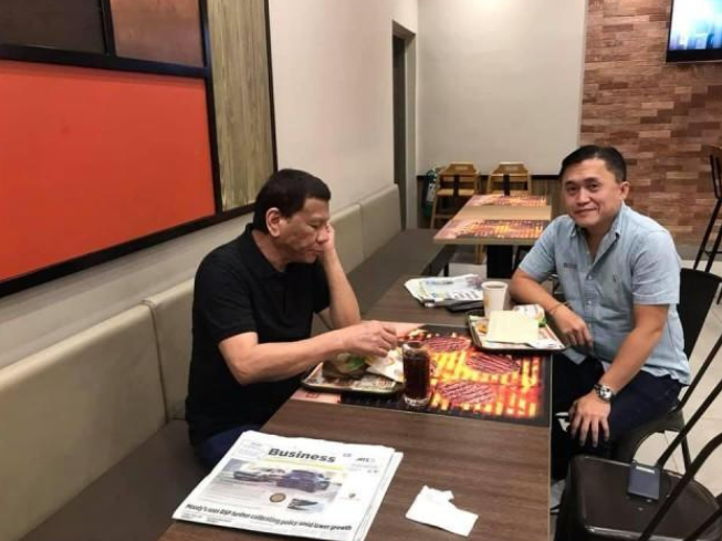 In photo: President Duterte, Senator Go share burger meal while reading ...